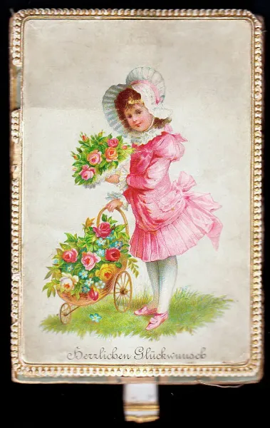 Girl with flowers and wheelbarrow on a German greetings